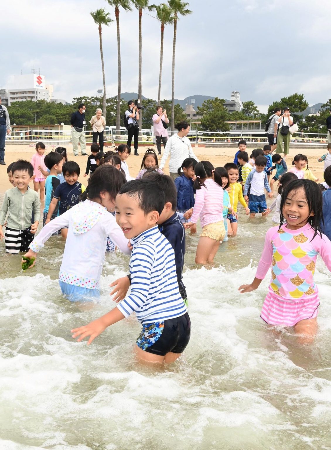 Joyful Splashing at Suma Beach as Delighted Children Rush into the Sea ...